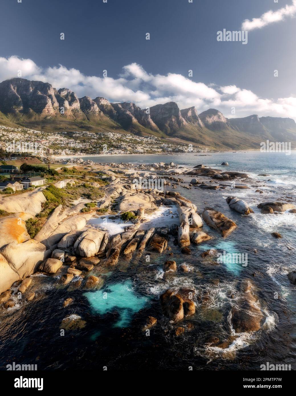 A mountain range at sunset with tropical blue rock pools and a white ...