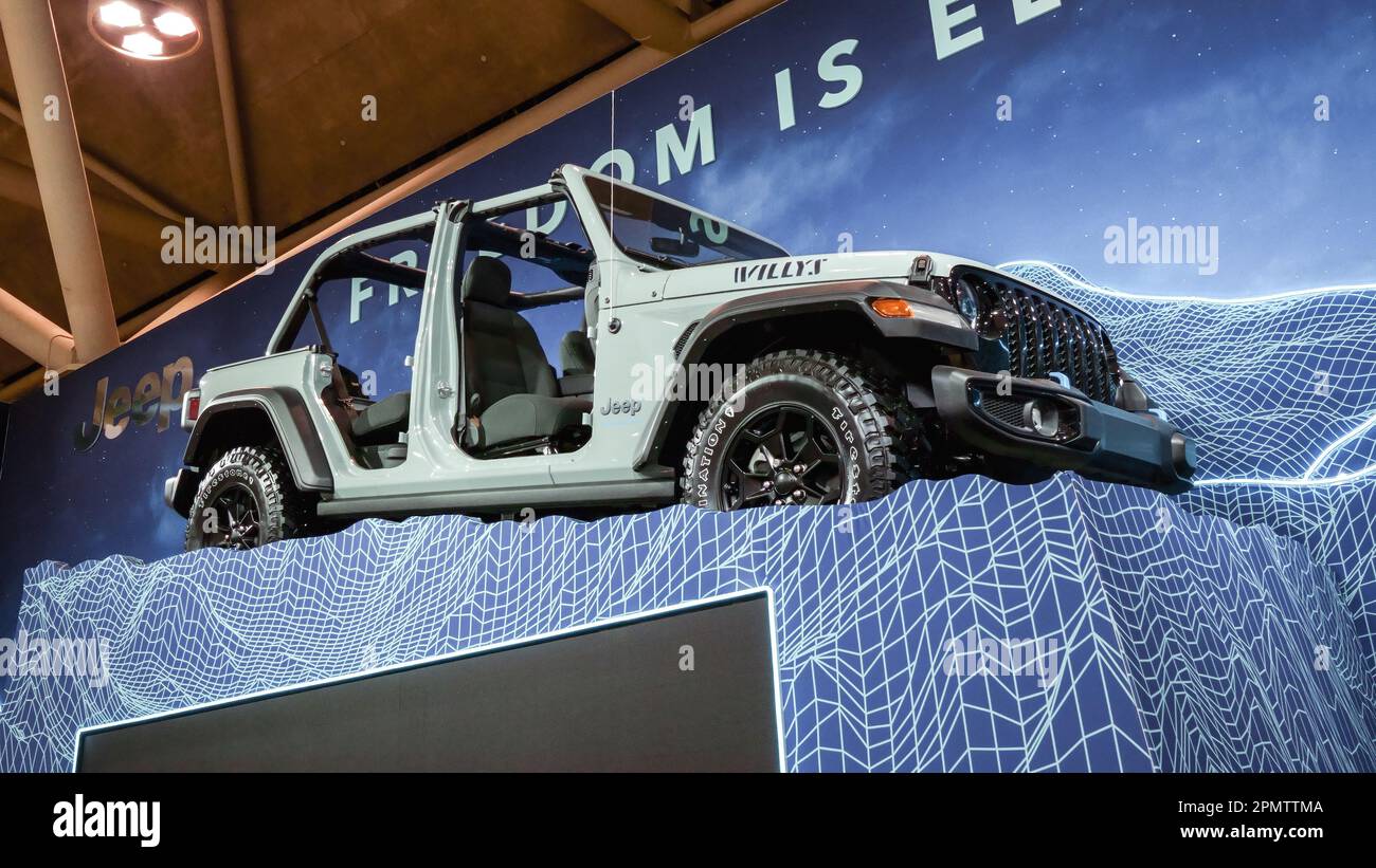 Grey Rubicon Jeep car on display. Crowds looking at new car models at ...