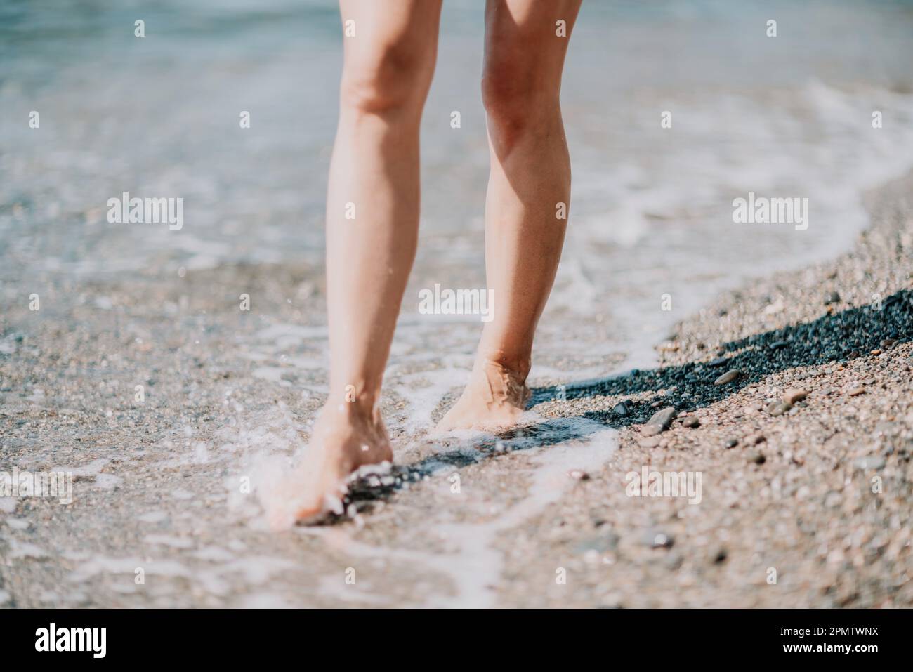 A woman walks along the beach, legs close-up. Barefoot woman sta Stock ...