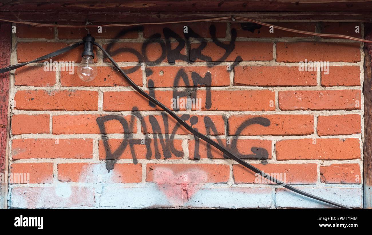 As graffiti written sorry i am dancing on a wall Stock Photo - Alamy
