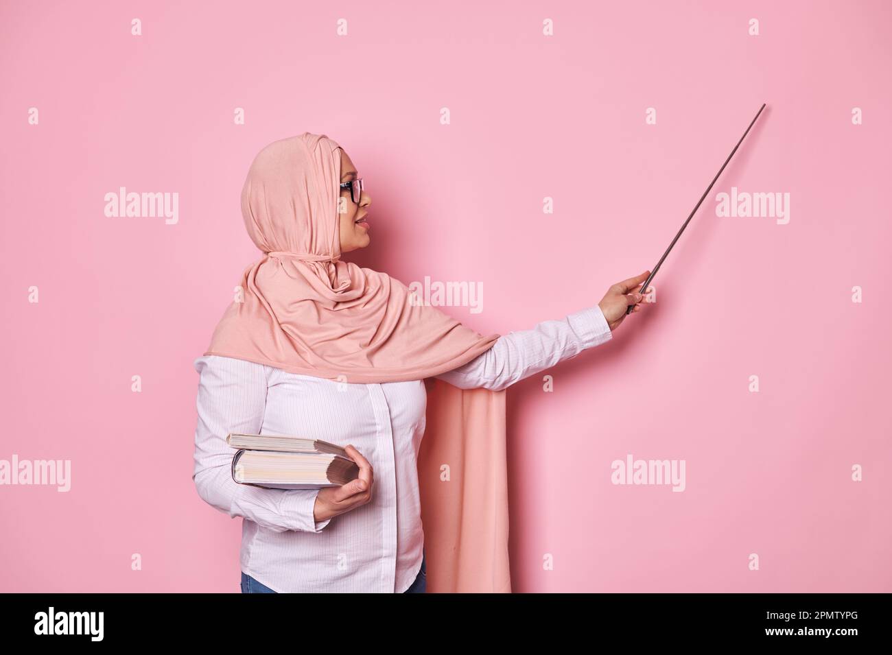 Confident Arab Muslim woman, school teacher pointing at copy space on ...