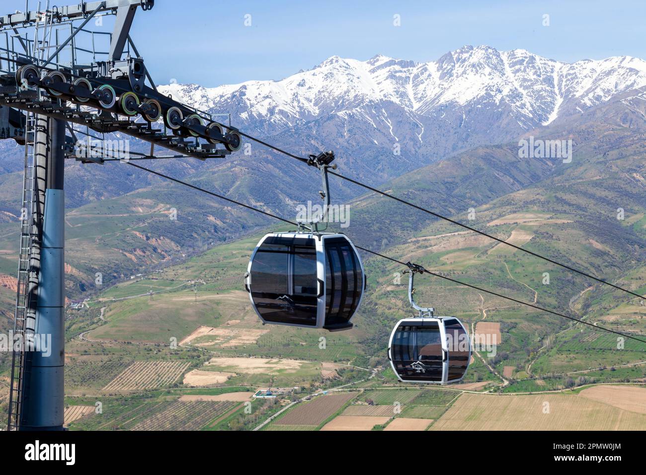 Cable car cabins with mountains on background, mountains with snow on a ...