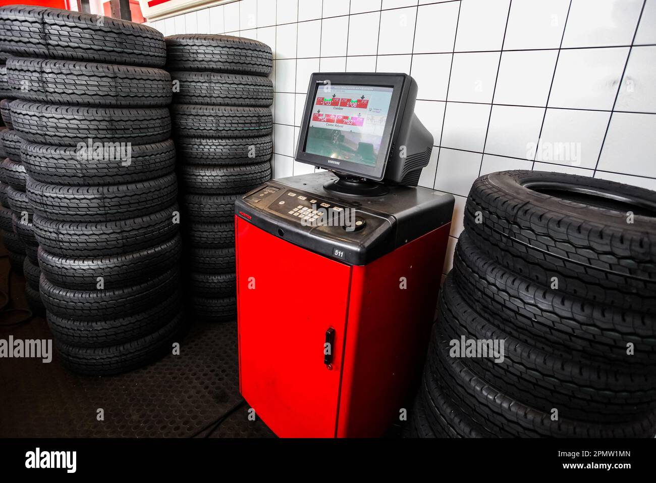 A garage with several rows of tires in frames against a white wall ...