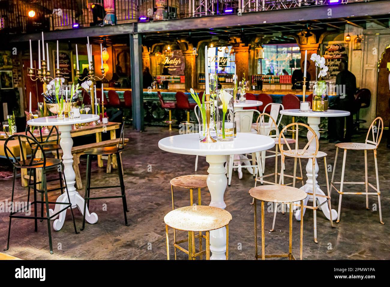 An interior scene featuring a bar setting with multiple tables and ...