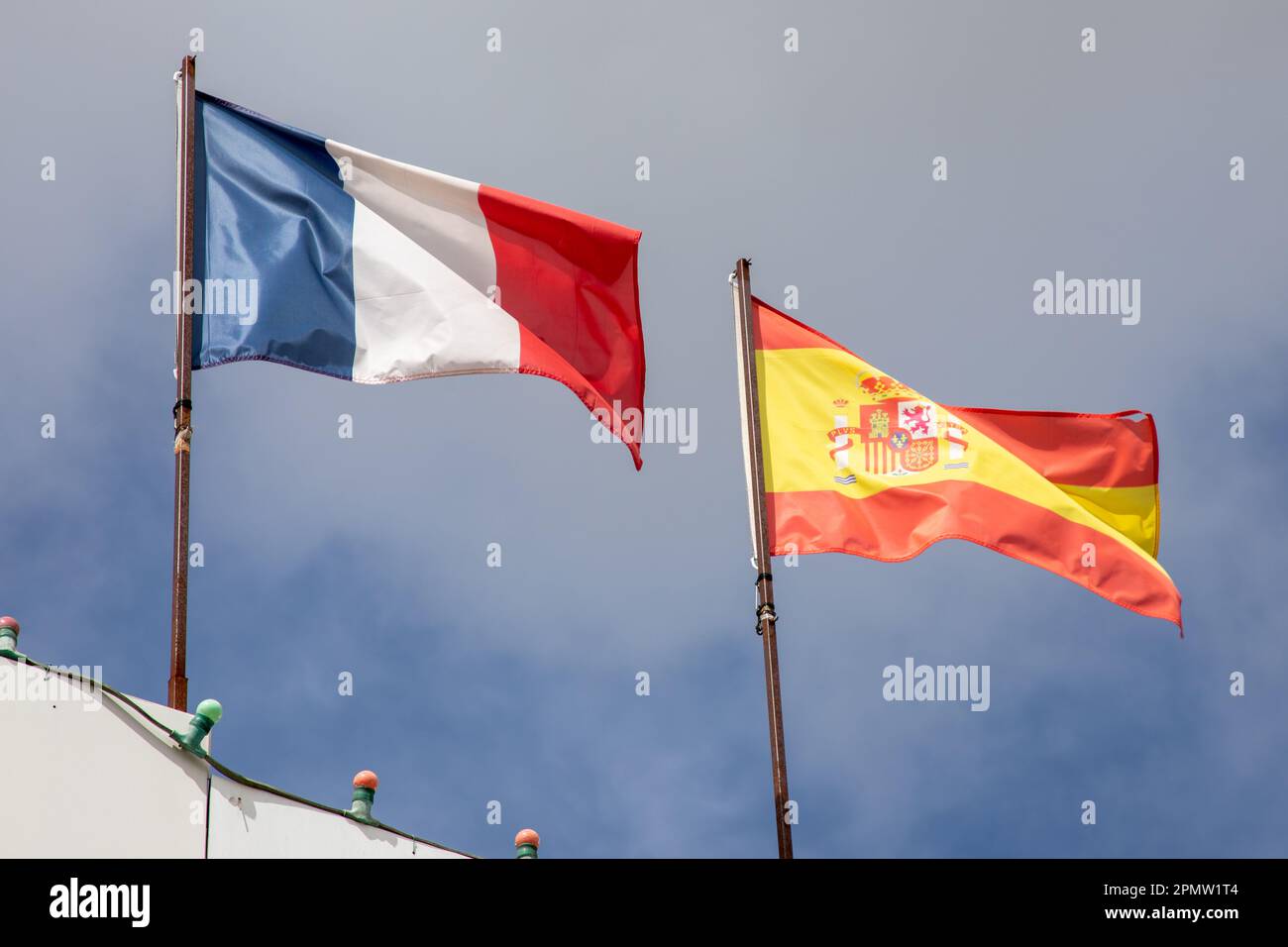 Spanish flag with France flag waving over cloud blue french spanish sky ...
