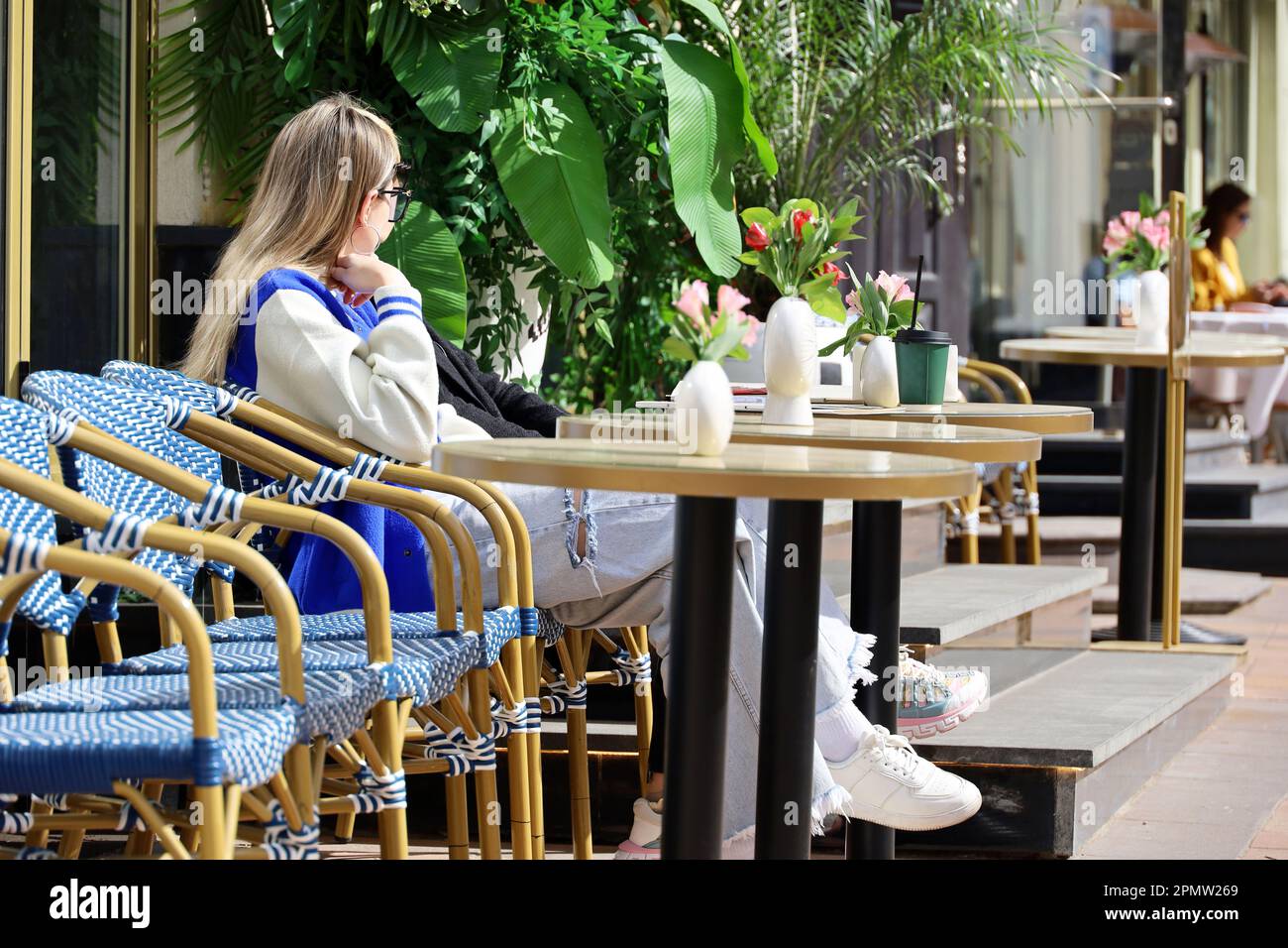 Two girls talk sitting on terrace of street cafe. Life and leisure in ...