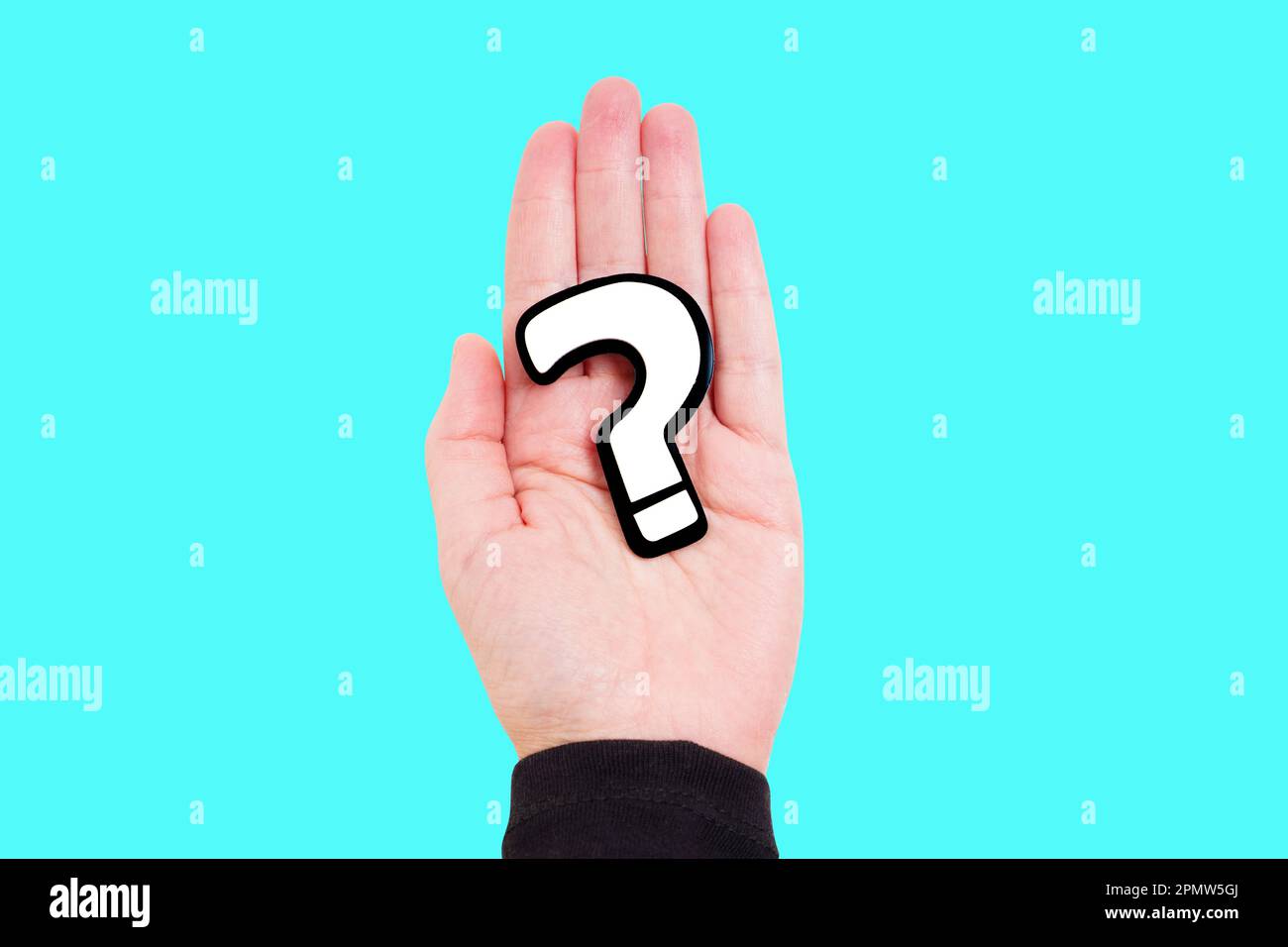 Crop view of a female hand with a large black and white question mark ...