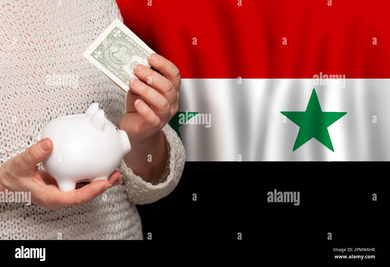 Syrian woman with money bank on the background of Syria flag. Dotations ...