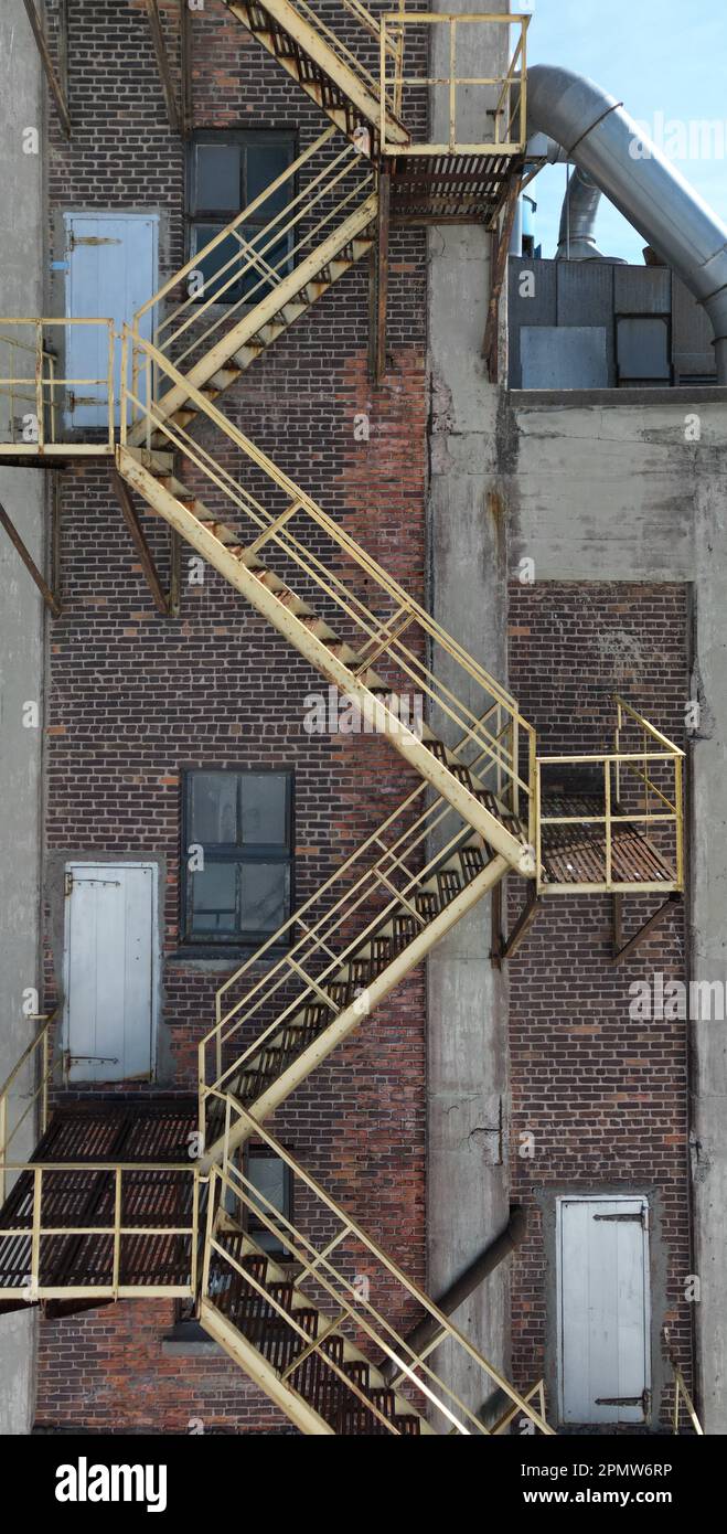 An exterior view of a tall brick building, featuring a fire escape ...