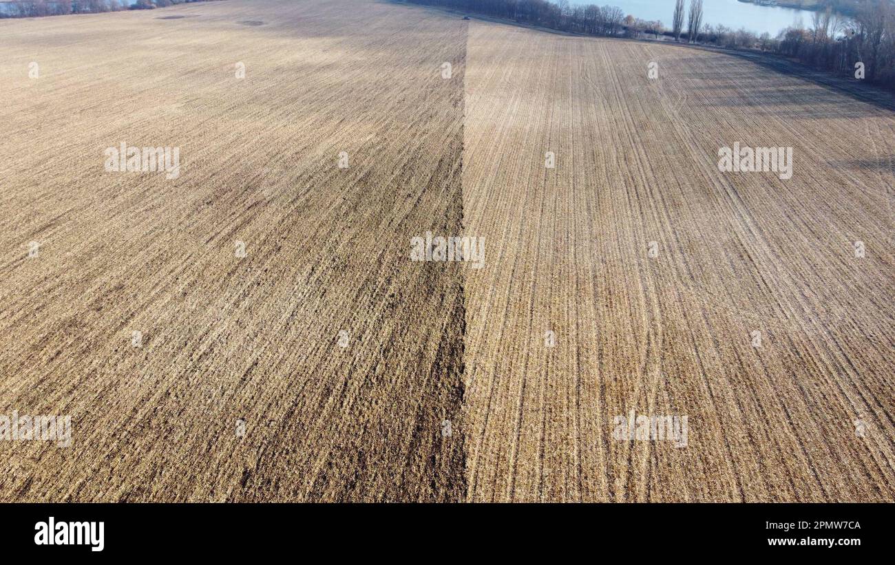 Half of large field after wheat harvest, half of field plowed. Flying ...