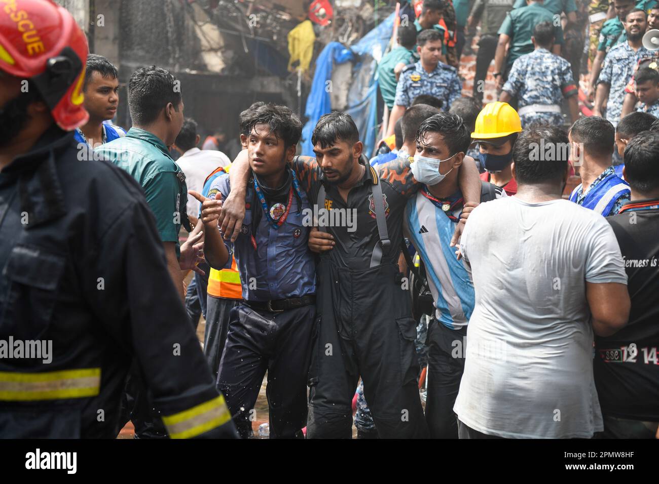 Volunteers help a sick firefighter after a horrendous fire guts shops ...
