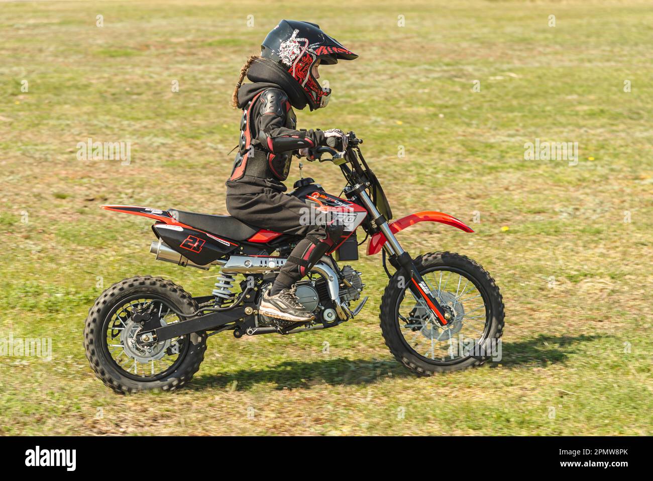 girl is racing on a racing motorcycle on a grass field Stock Photo - Alamy