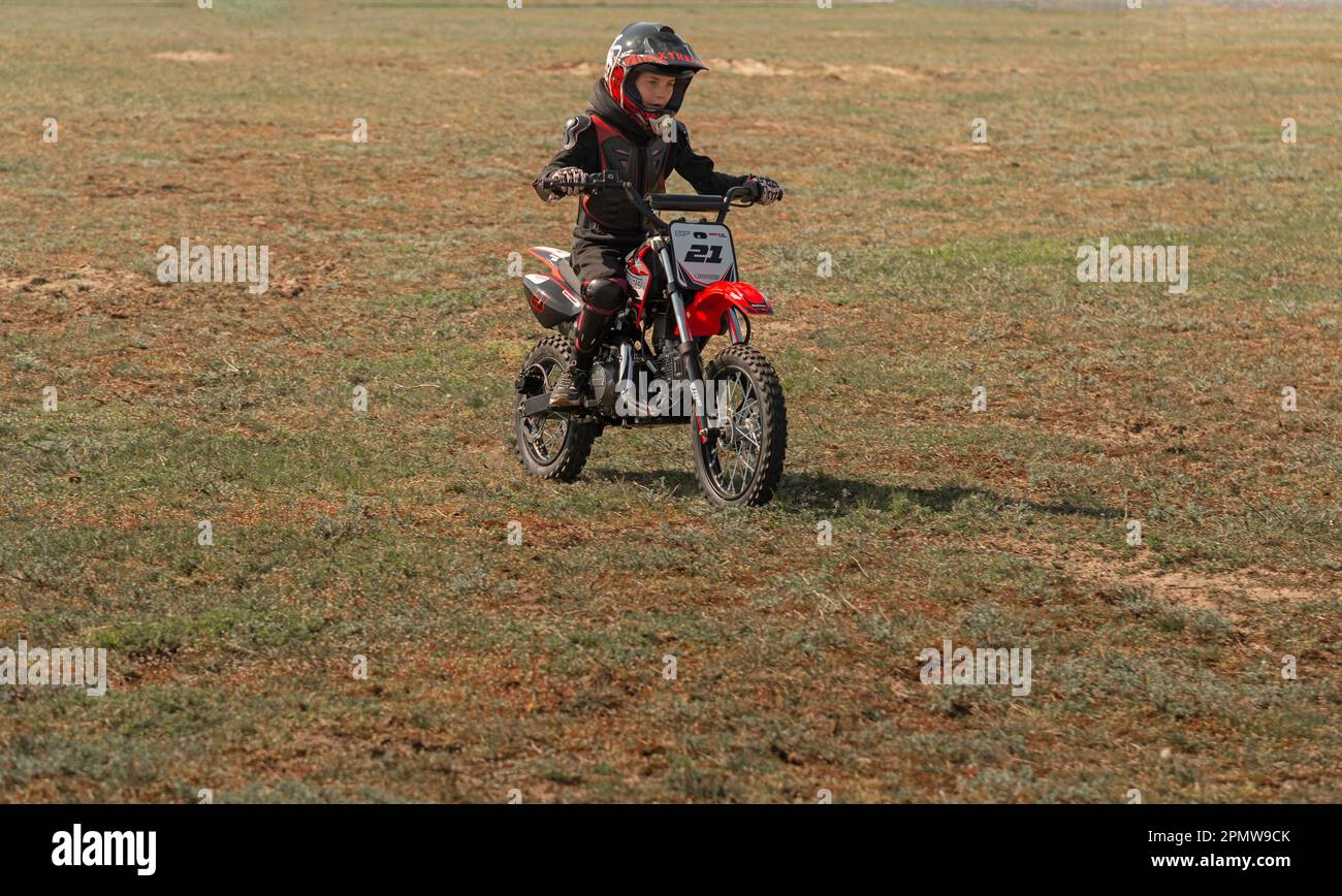 little girl is racing on a racing motorcycle on a lawn Stock Photo - Alamy