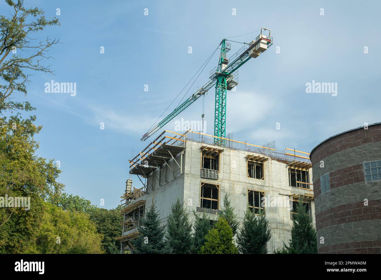 A tall crane stands by a building under construction Stock Photo - Alamy