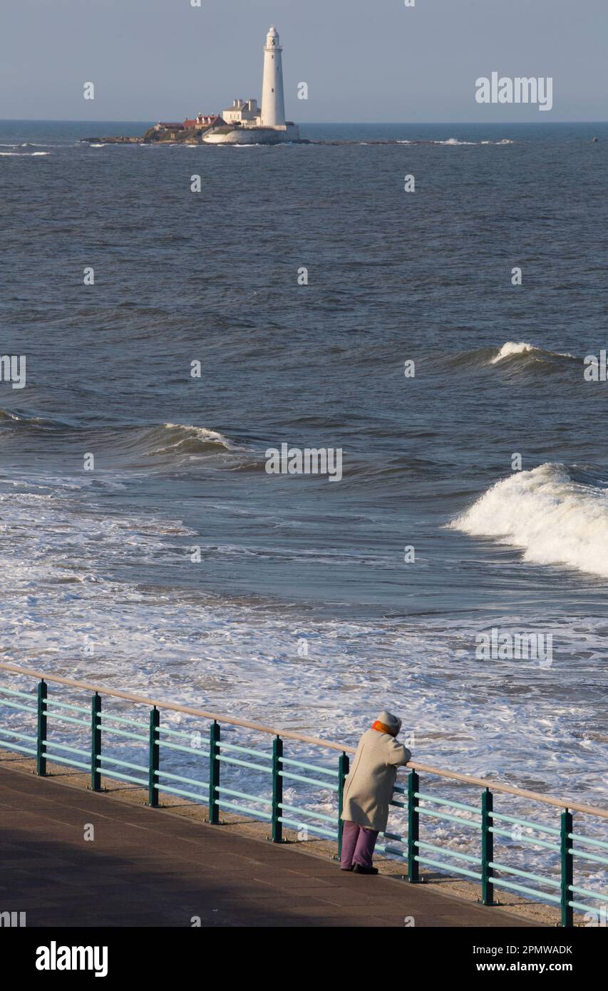 Older woman staring out at the sea at Whitley Bay with St.Marys ...