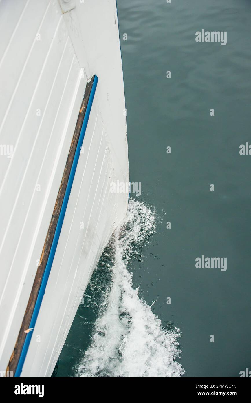 Water passing the bow of a white wooden boat Stock Photo - Alamy
