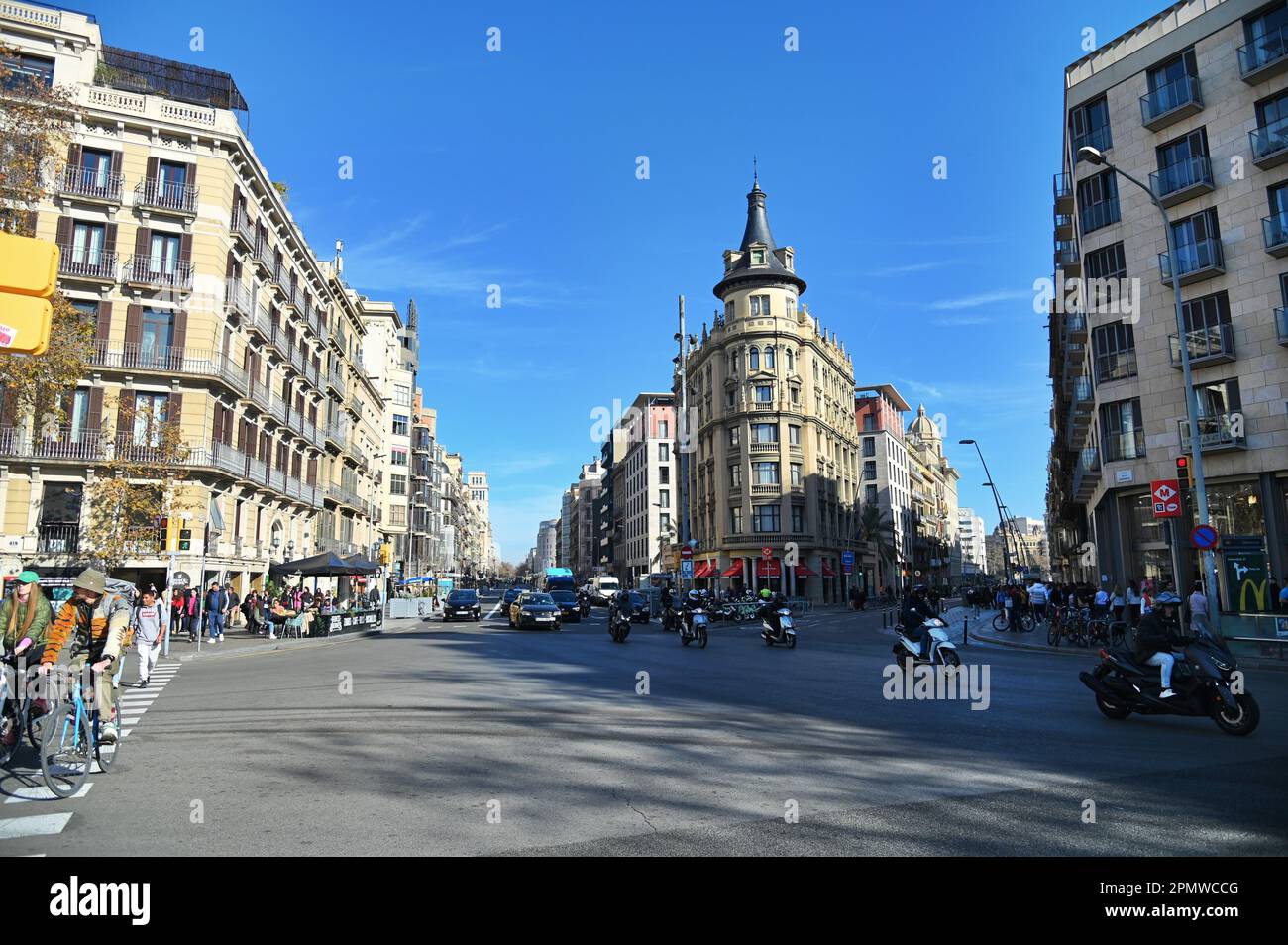 A busy downtown street with motorcycles and cars on a sunny day in ...