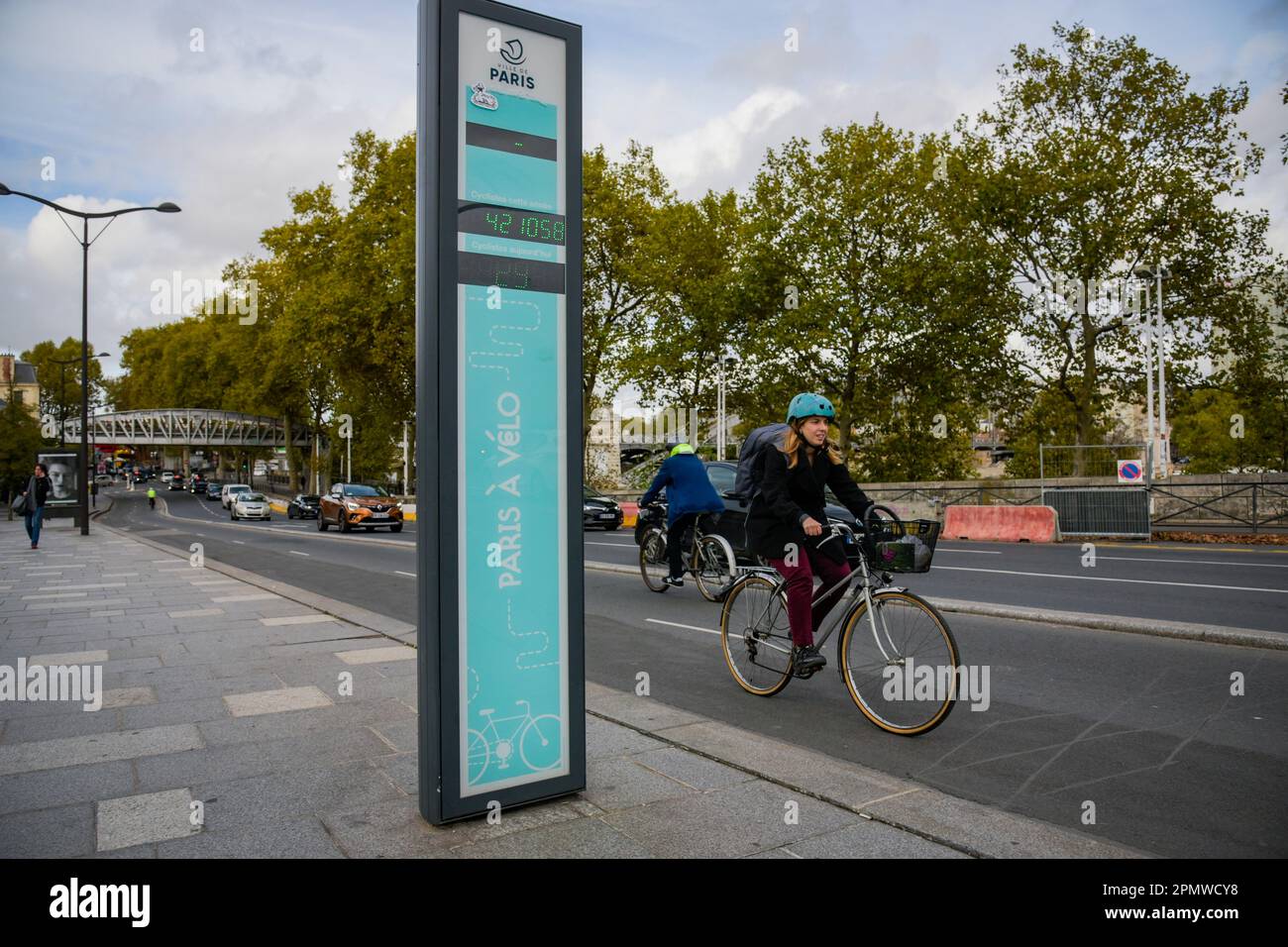 Paris - France - November 2022: street view of a woman cycling past a ...