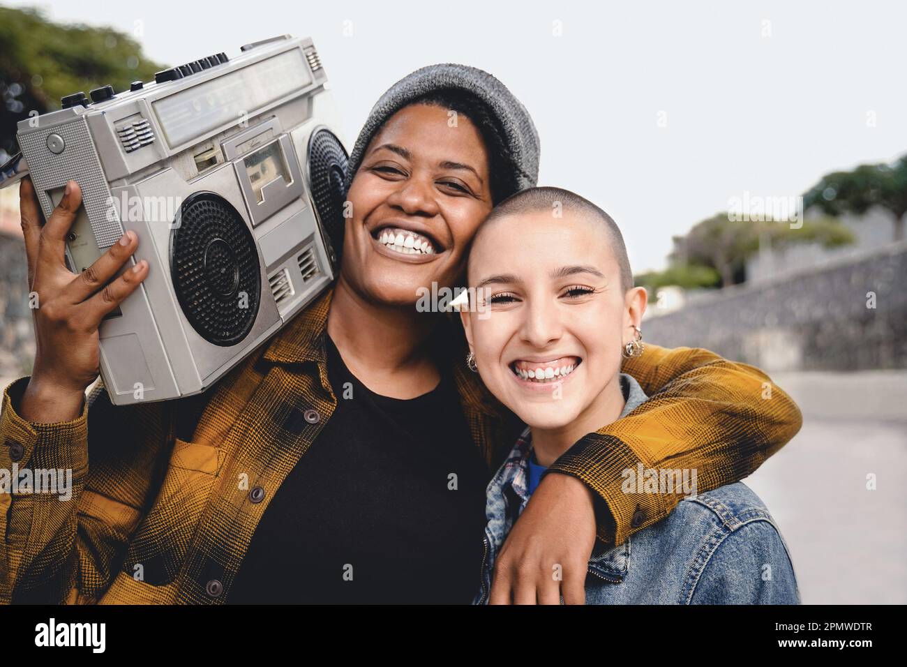 Diverse multiracial people listening to urban music outdoors with city ...
