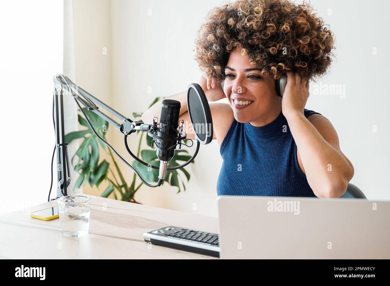 African host woman recording podcast using microphone at home studio ...