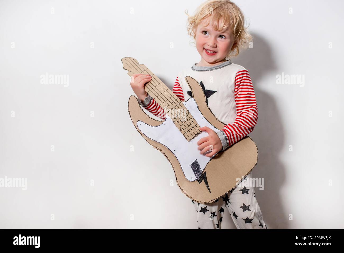 little funny girl with DIY guitar. musical instrument handmade of ...