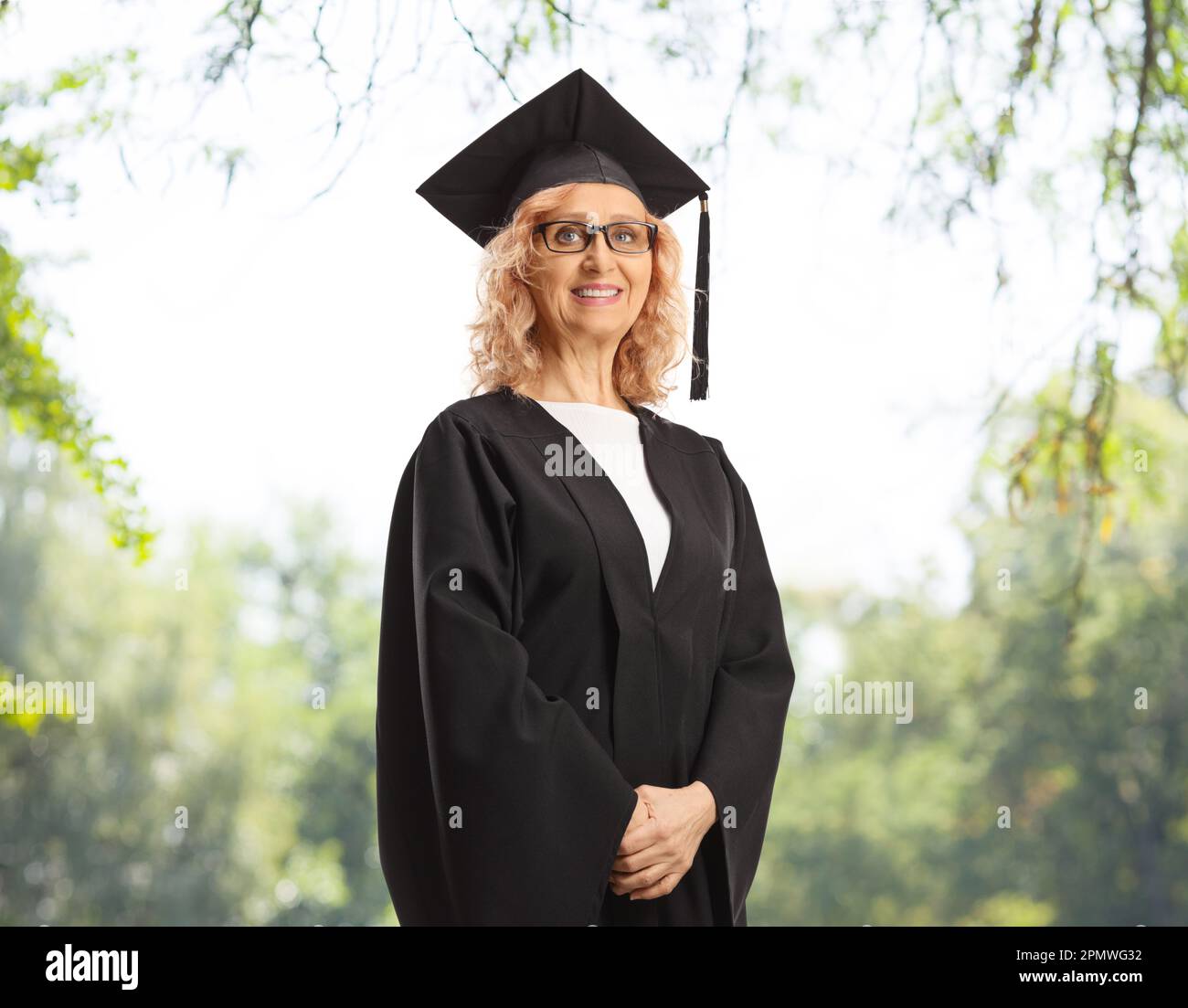 Marture woman wearing a graduate gown and posing outdoors Stock Photo ...