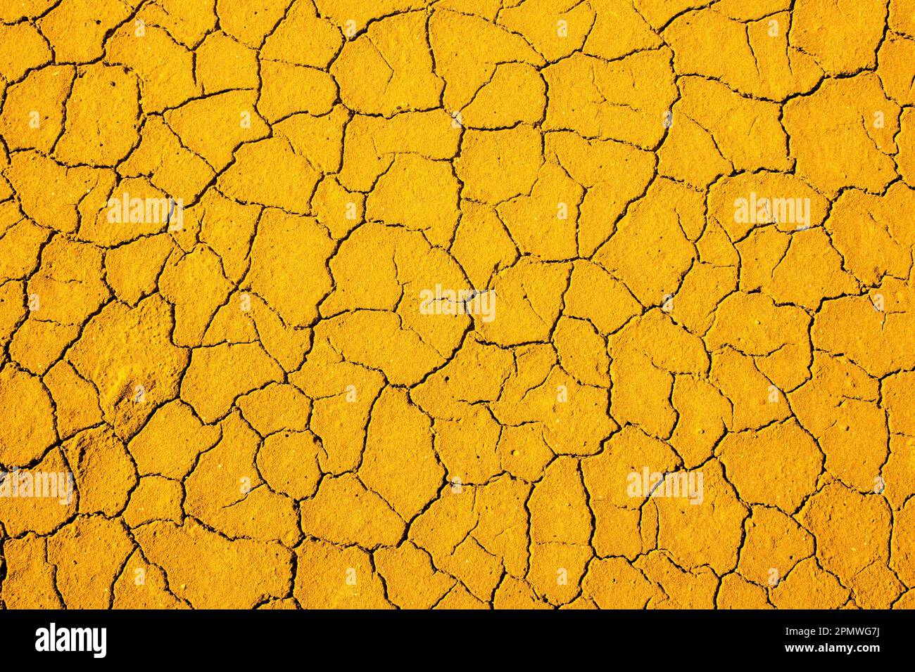 A bright yellow ground surface with cracks Stock Photo - Alamy