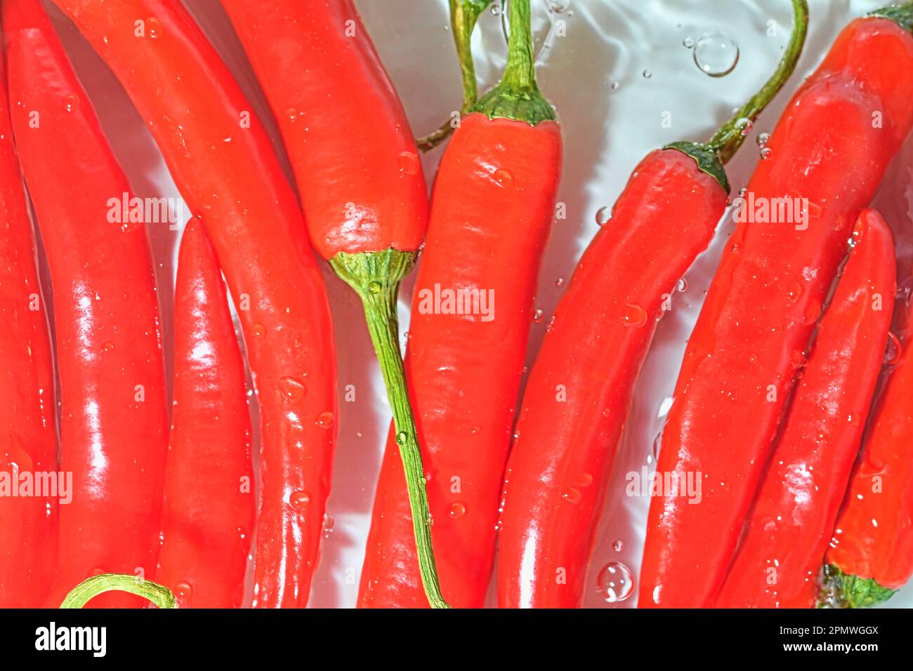 Close-up of fresh slices chilli peppers on white background. Red chilli ...