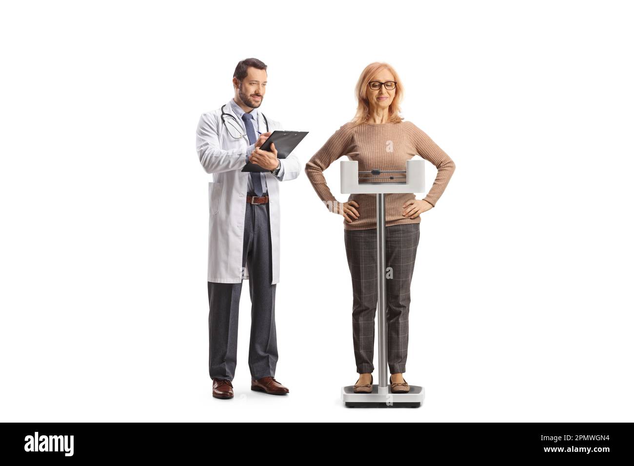 Doctor and a mature woman standing on a weight scale isolated on white ...