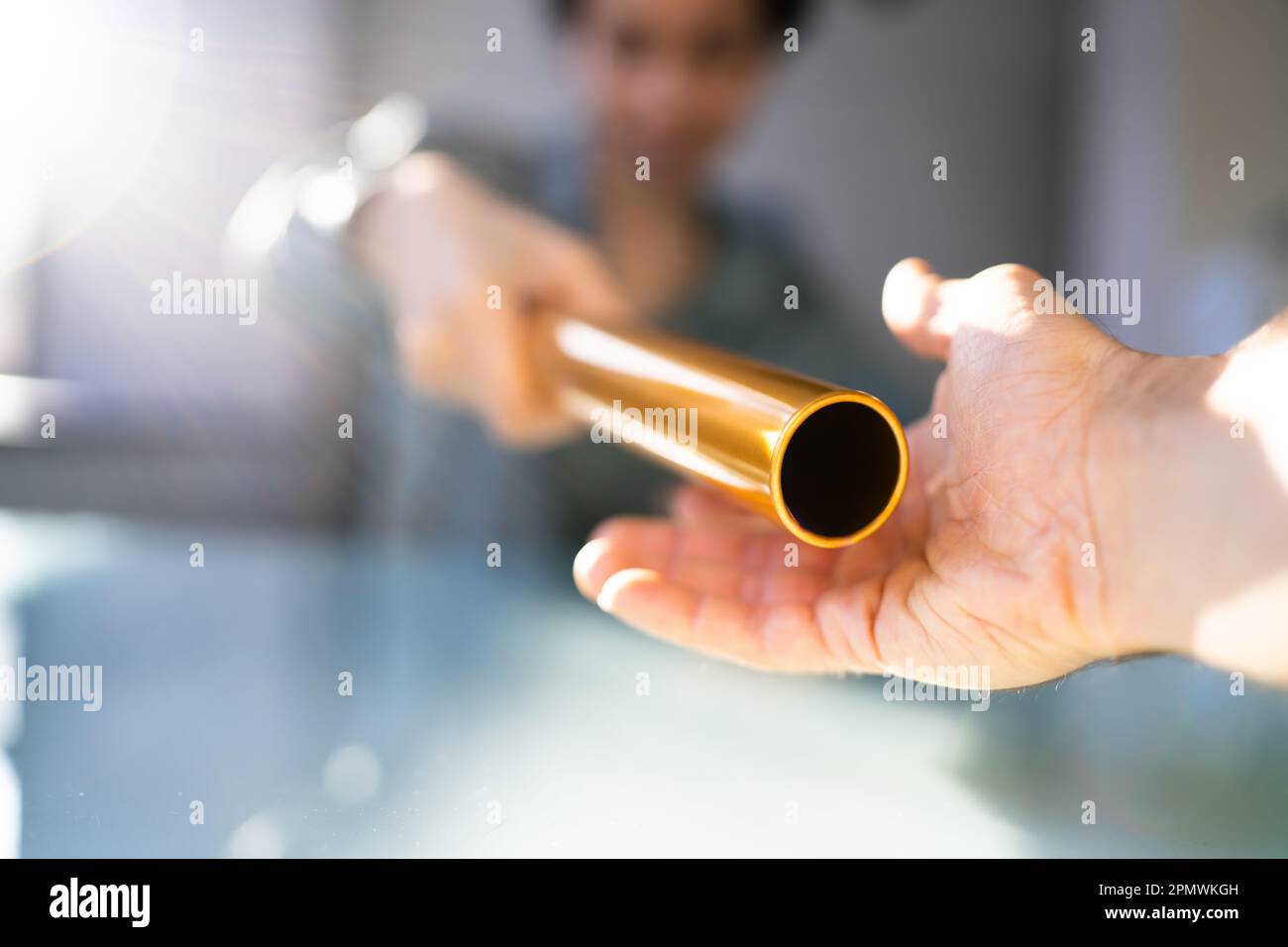 Hand Passing Golden Relay Baton To Businesswoman Stock Photo - Alamy