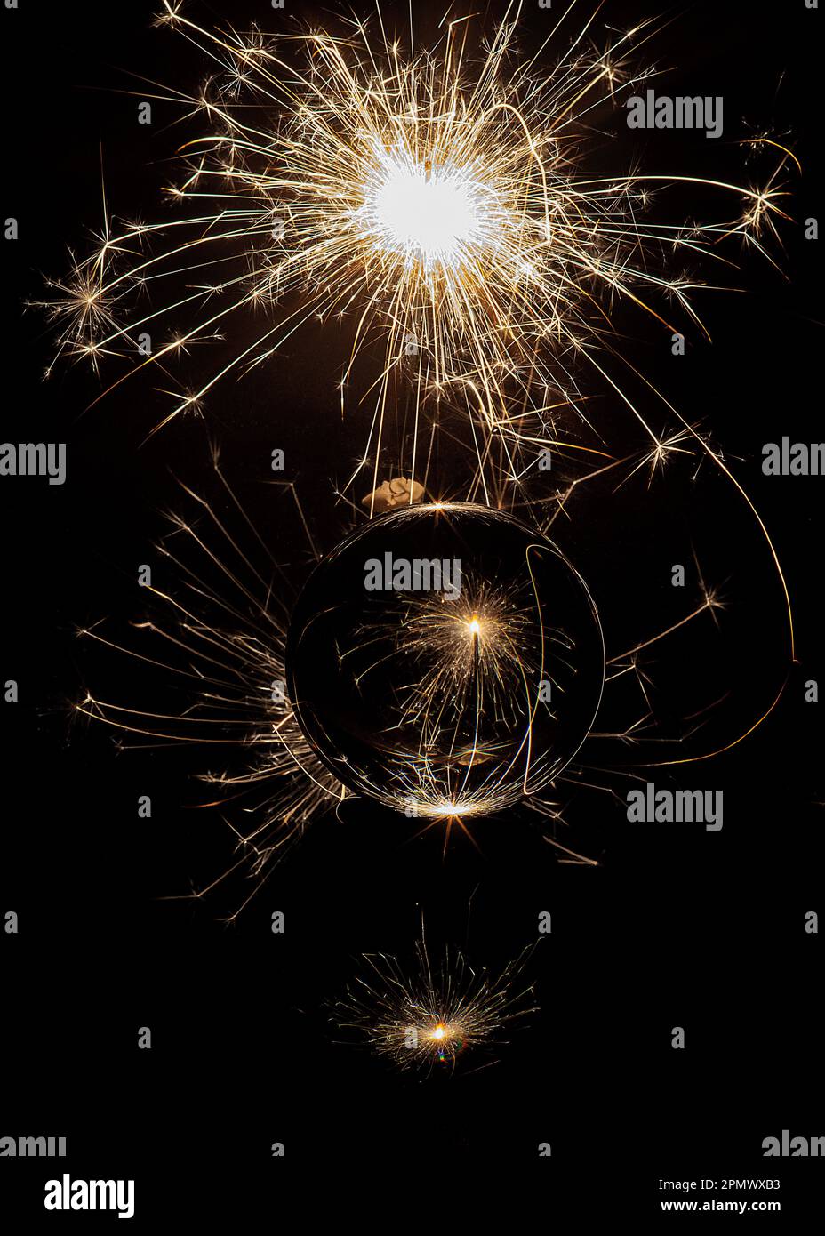 A vertical shot of a reflective glass ball in front of exploding ...