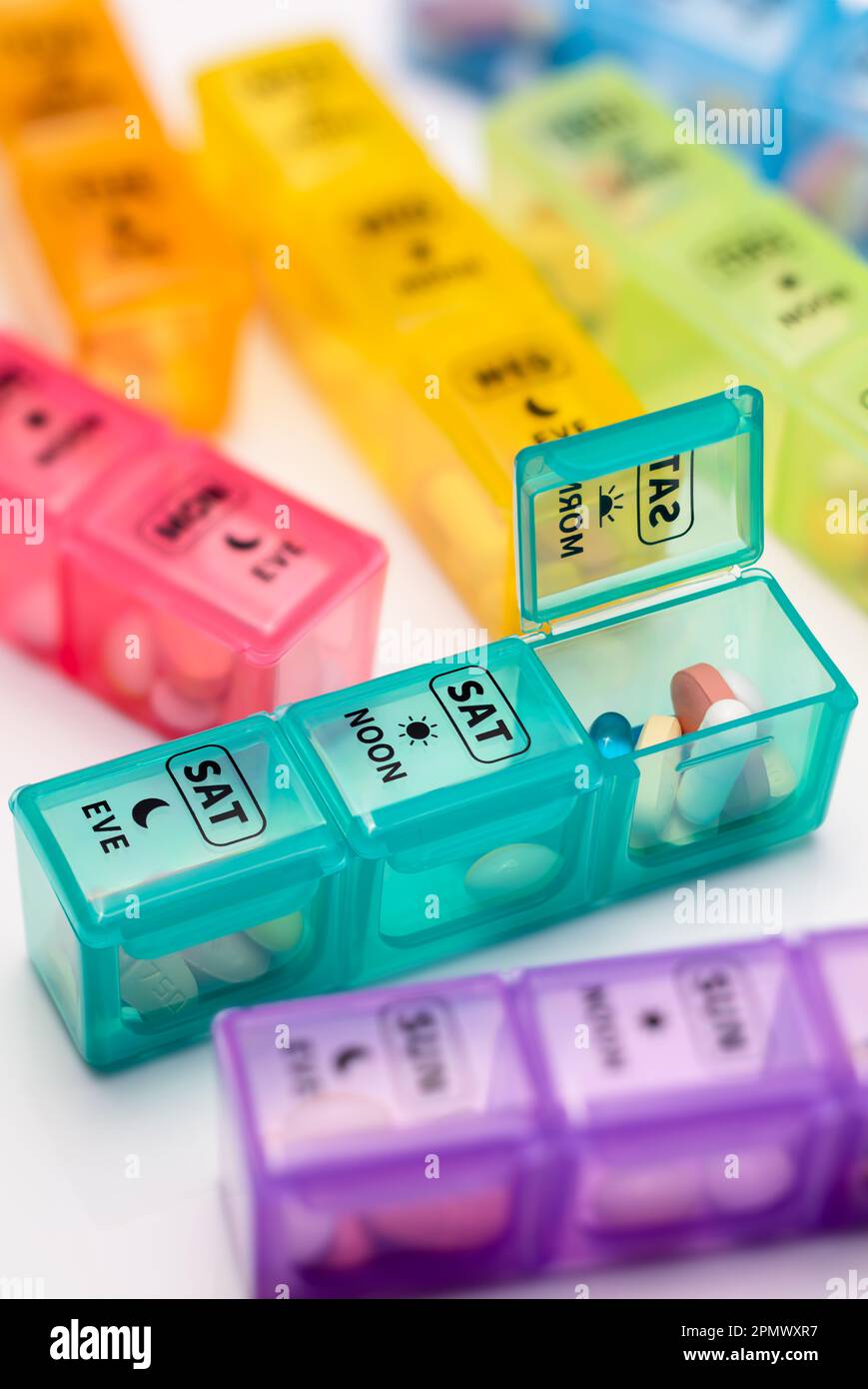 Capsules and pills inside a tablet organiser surrounded by other ...
