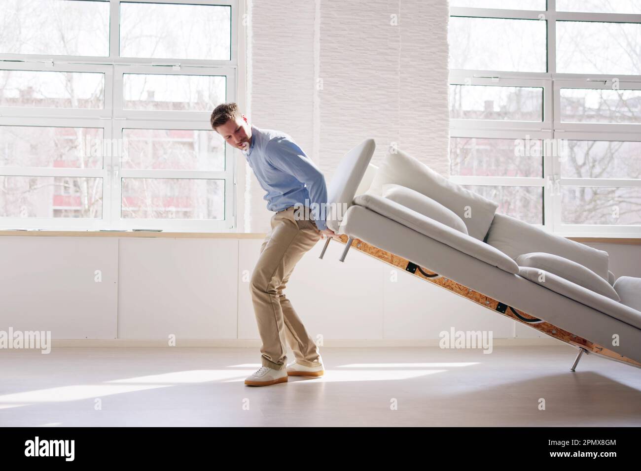 Men Carrying Furniture. Moving Sofa In Living Room Stock Photo - Alamy
