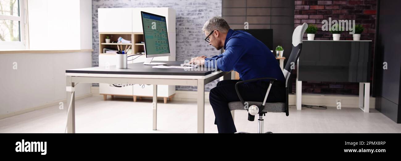 Bad Posture Sitting In Office Chair At Computer Desk Stock Photo - Alamy