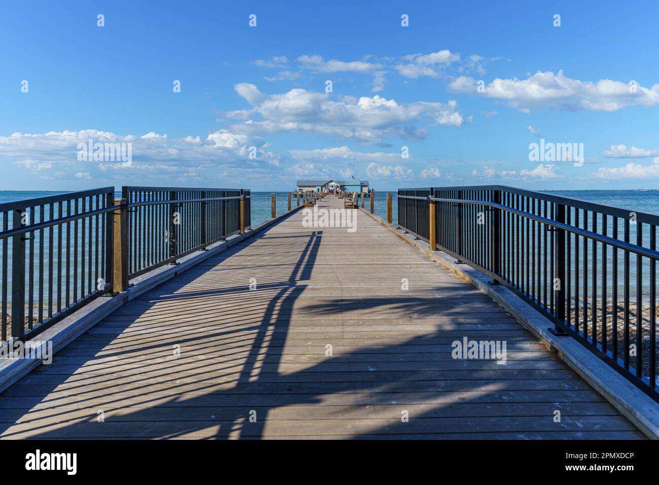 A long pier leading out into the ocean on a warm sunny day at Holmes ...
