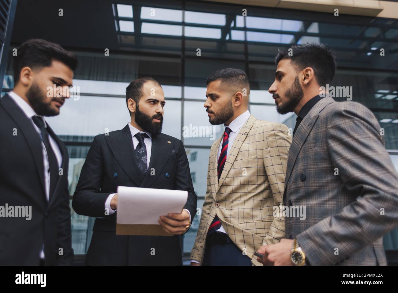 Business people outdoor meeting. Men in jackets discuss working moments ...