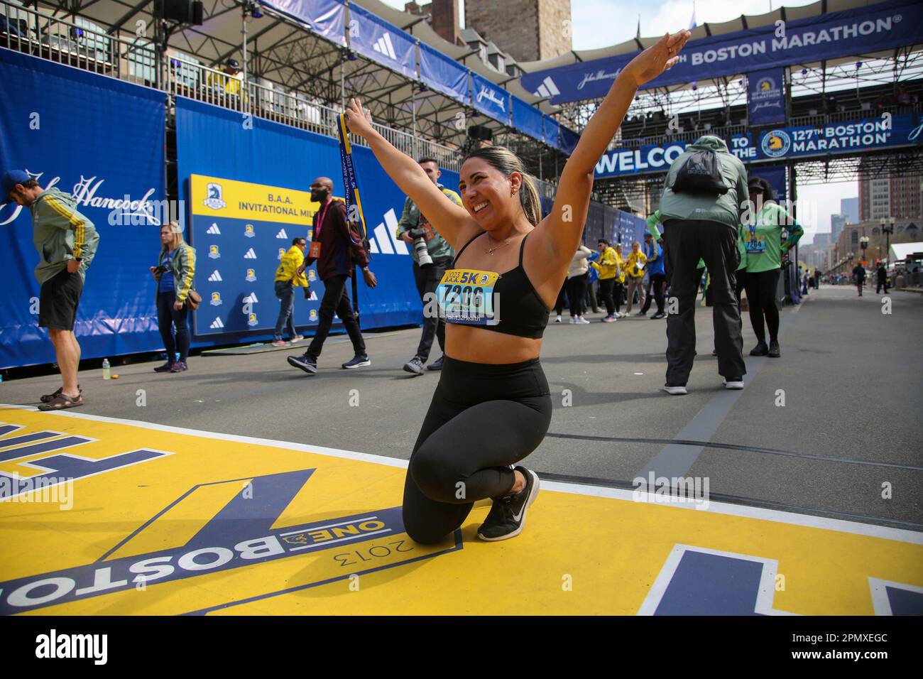 5K runner Karen Lopez of Somerville, Mass., poses at the finish line of ...