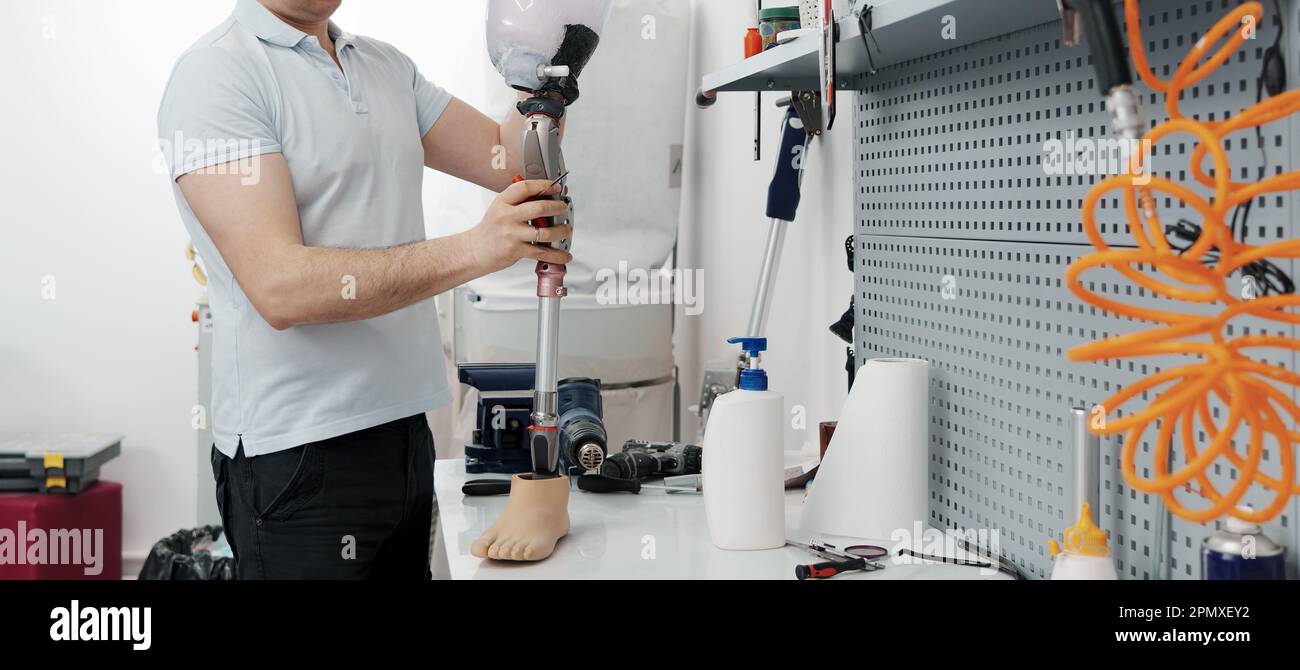 Crop unrecognizable craftsman adjusting and bending modern prosthetic ...