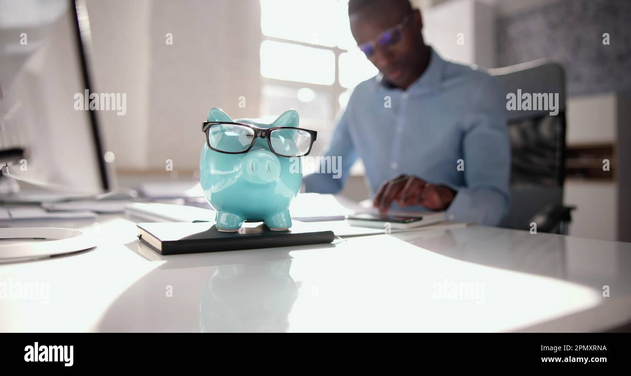 African Accounting Tax Advisor Using Calculator And Piggy Bank Stock ...