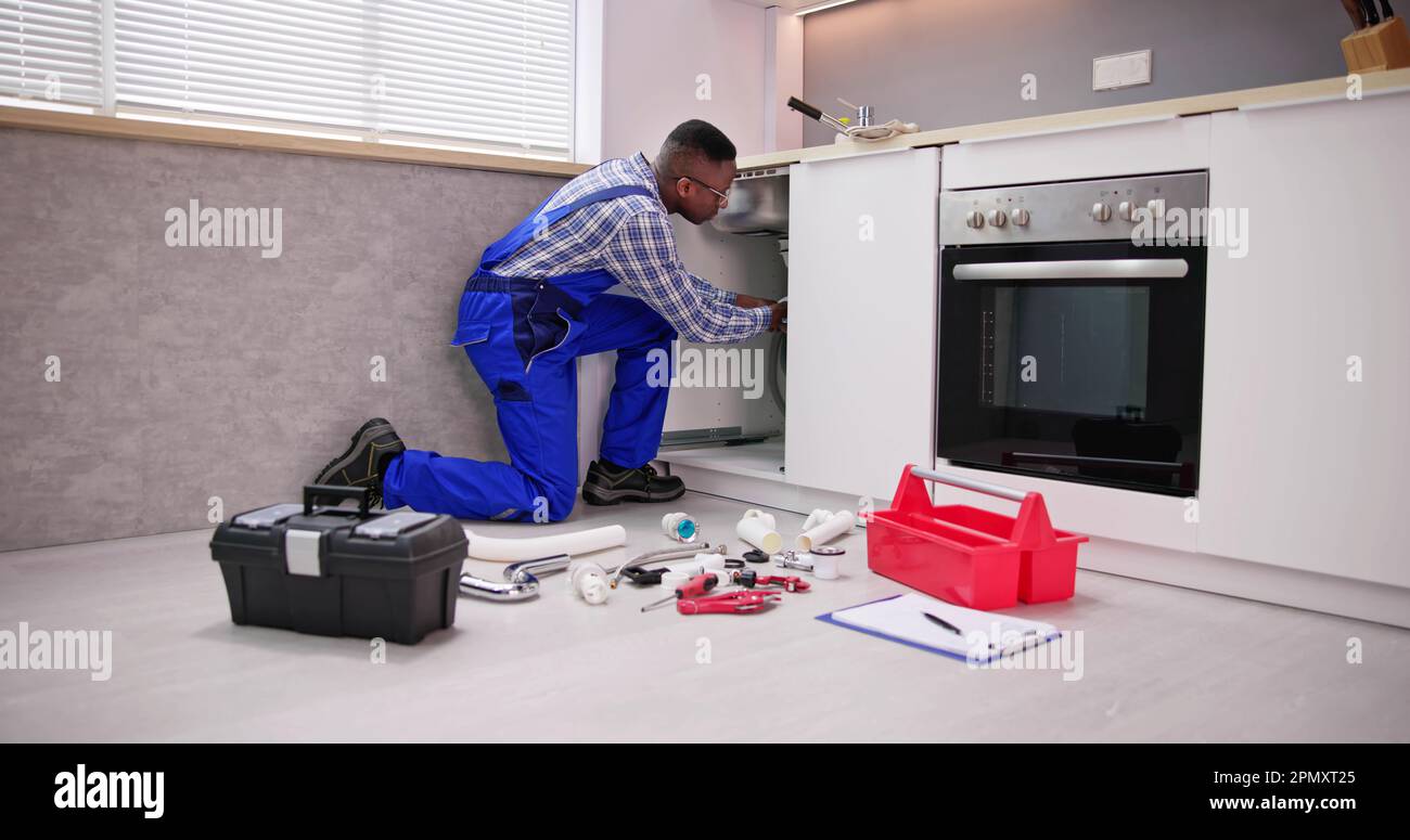 Plumber Cleaning Kitchen Drain And Pipe Using Tools Stock Photo - Alamy