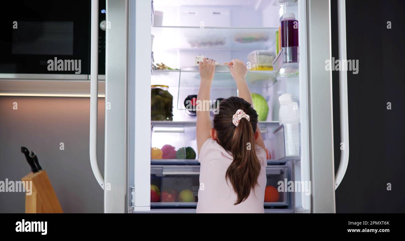 Child Girl Taking Food Fridge At Night Stock Photo - Alamy