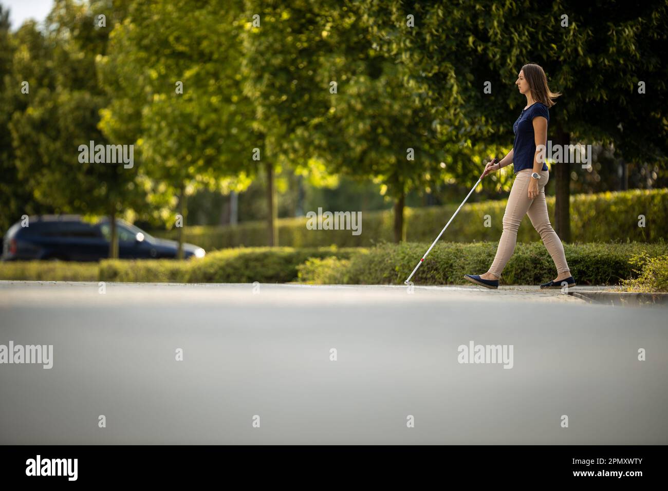 Young woman with impaired vision walking on city streets, using her ...