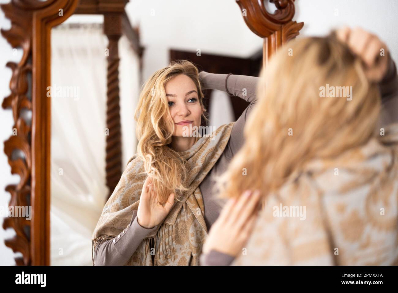 Pretty, young woman getting ready to go out in front of a mirror Stock ...