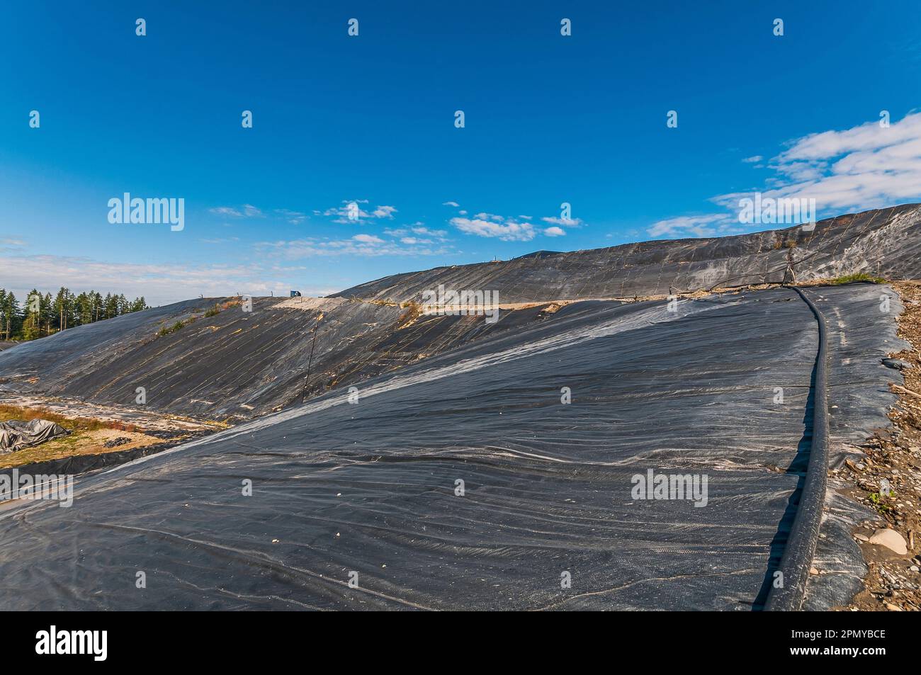 Geomembranes on hills and excavations in the distance below in an ...