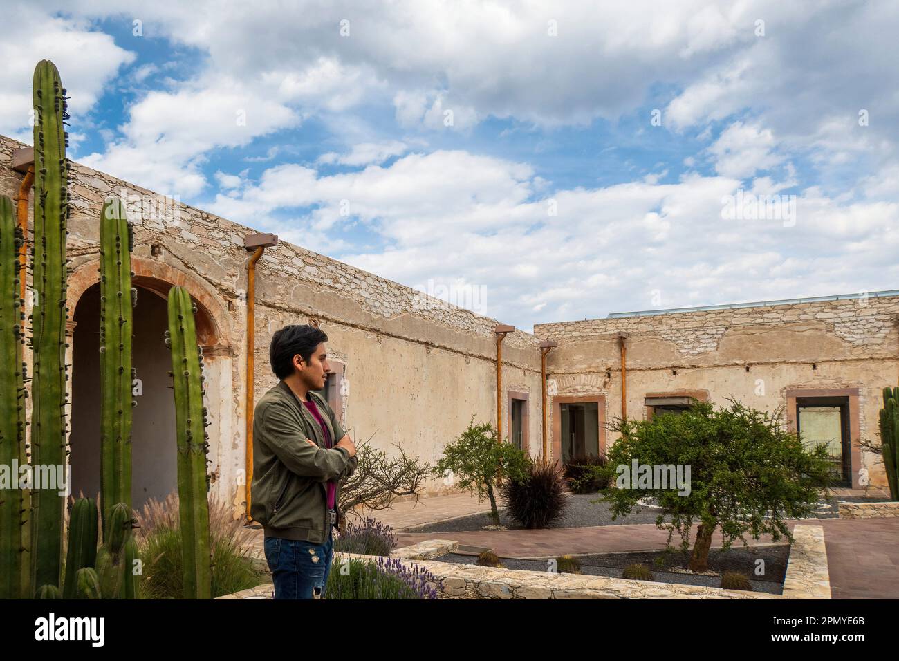 A man visiting the old rustic model school with cactus in Mineral de ...