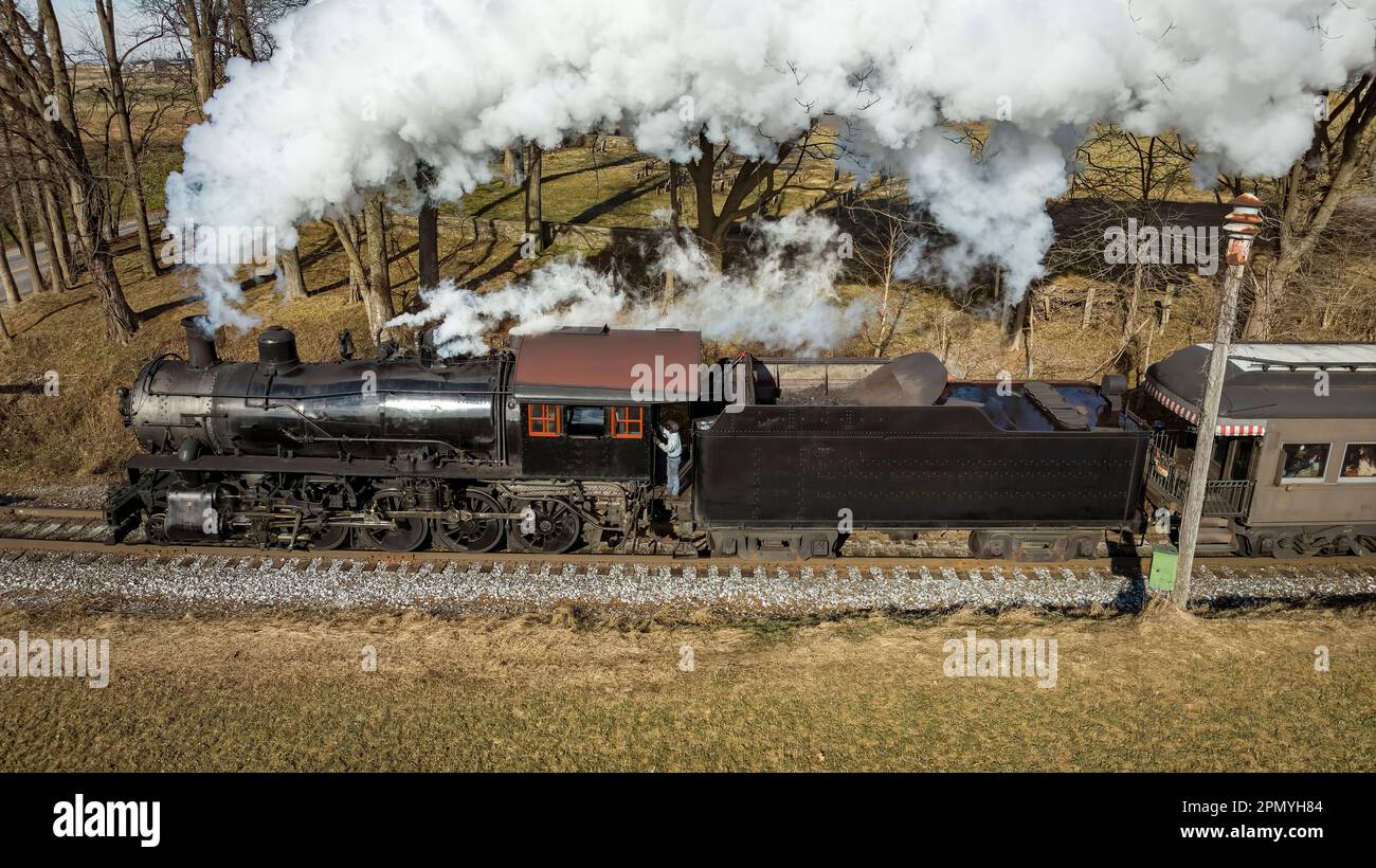 An aerial view of a steam train on tracks through a rural countryside ...