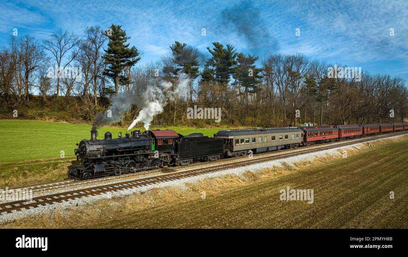An aerial view of a steam train on tracks through a rural countryside ...