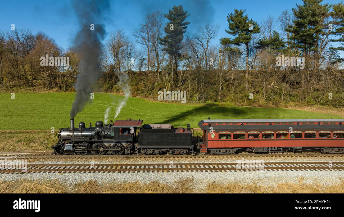 An aerial view of a steam train on tracks through a rural countryside ...