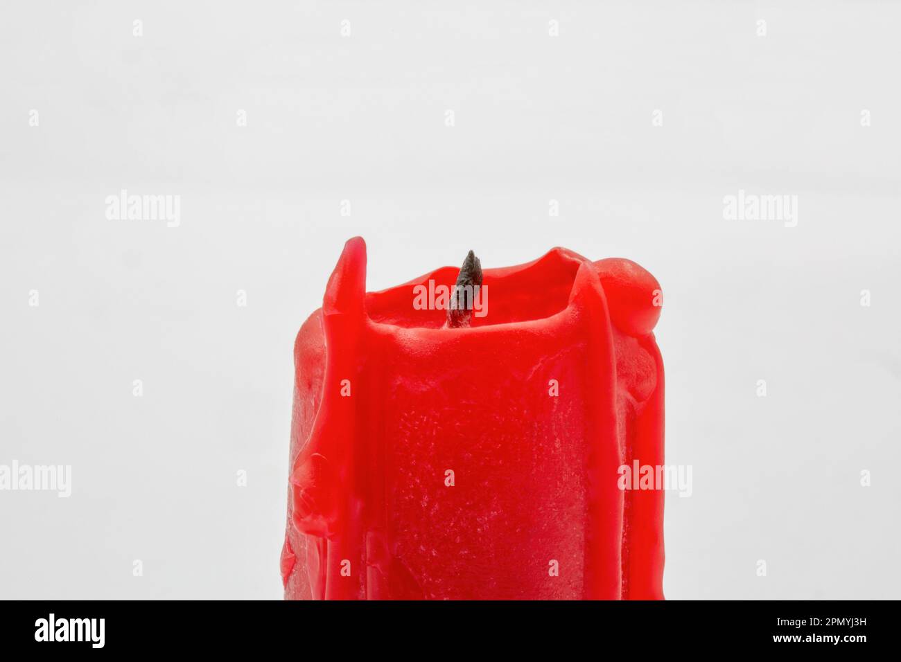 small red candle stub closeup on white background Stock Photo - Alamy