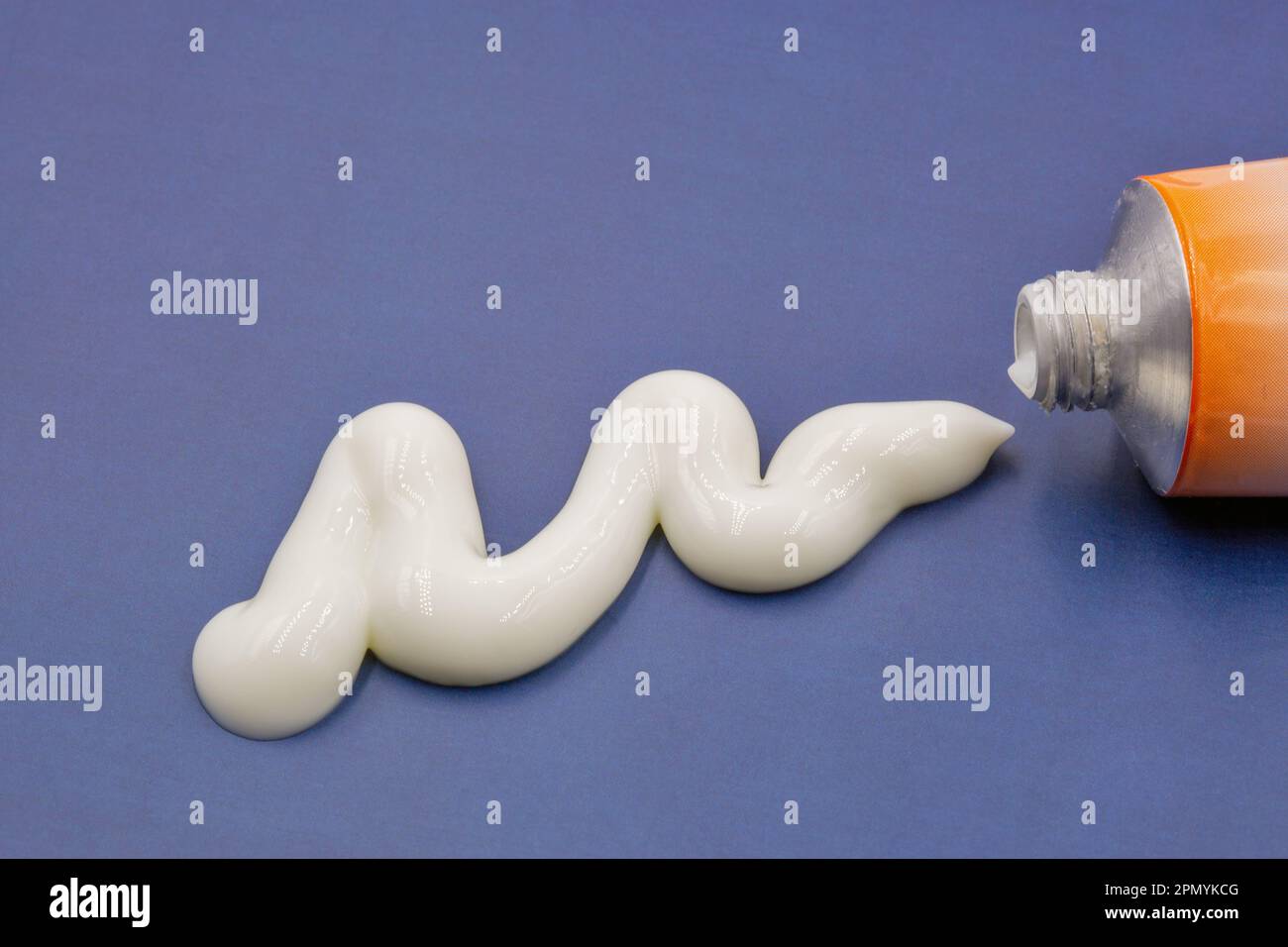 Squiggly line of compounded white cream being squeezed out of a ...